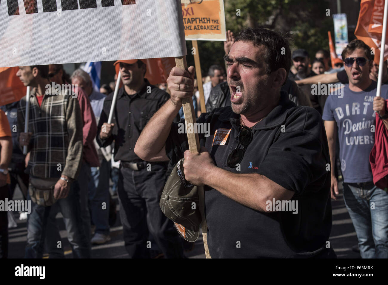 Protesters march towards the Greek Parliament holding banners and ...