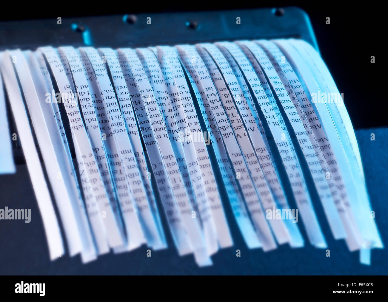 Strips of paper coming out of a shredder Stock Photo - Alamy