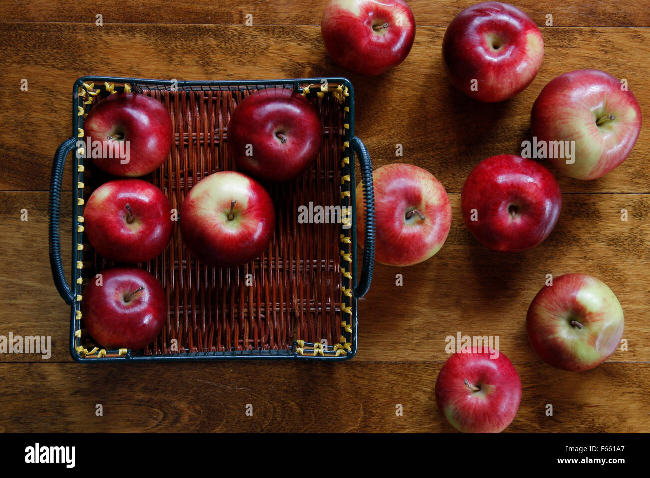 Birds eye view of several Apples scattered, inside and outside a basket ...