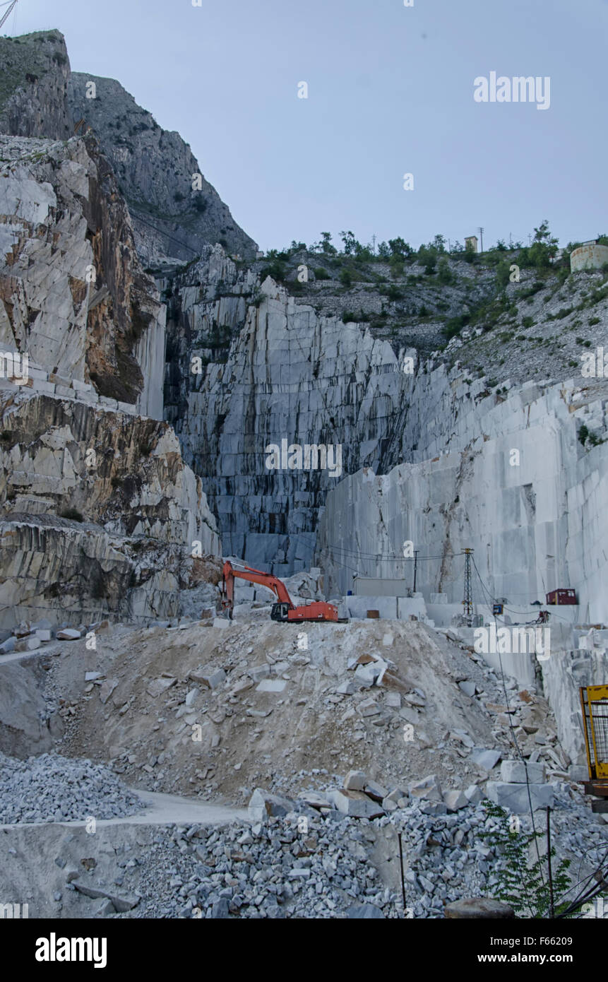 Excavators working in mine marble in Italy Stock Photo - Alamy
