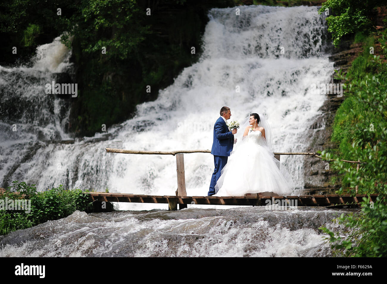 beautiful wedding couple near waterfall Stock Photo - Alamy