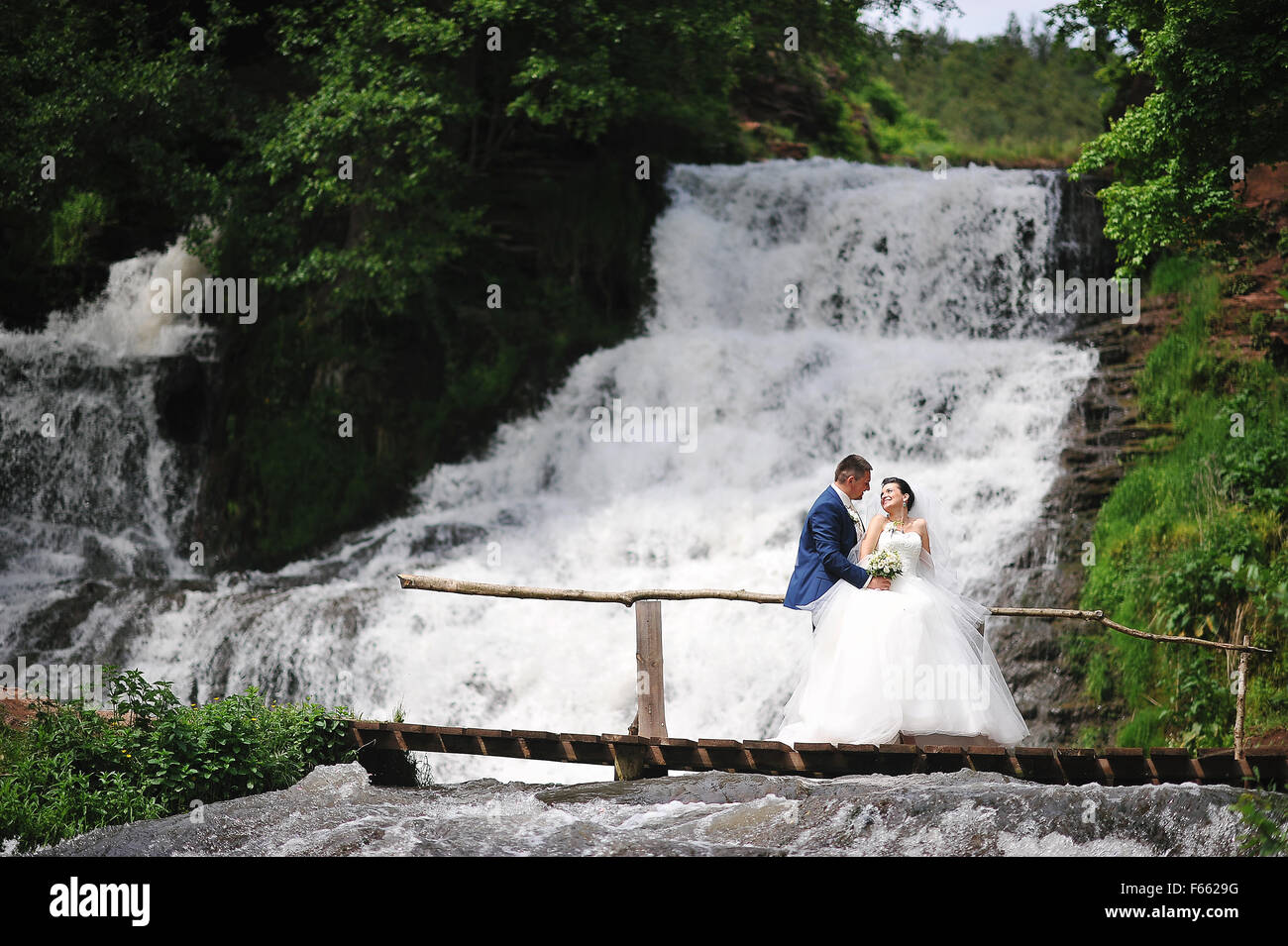 beautiful wedding couple near waterfall Stock Photo - Alamy