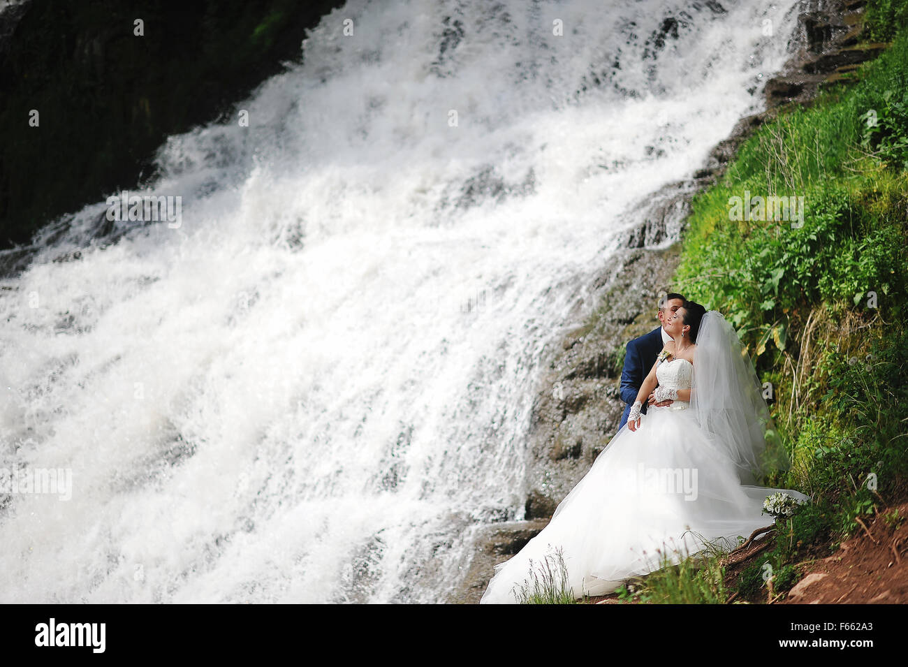 beautiful wedding couple near waterfall Stock Photo - Alamy