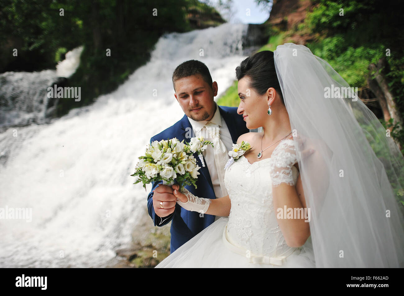 beautiful wedding couple near waterfall Stock Photo - Alamy