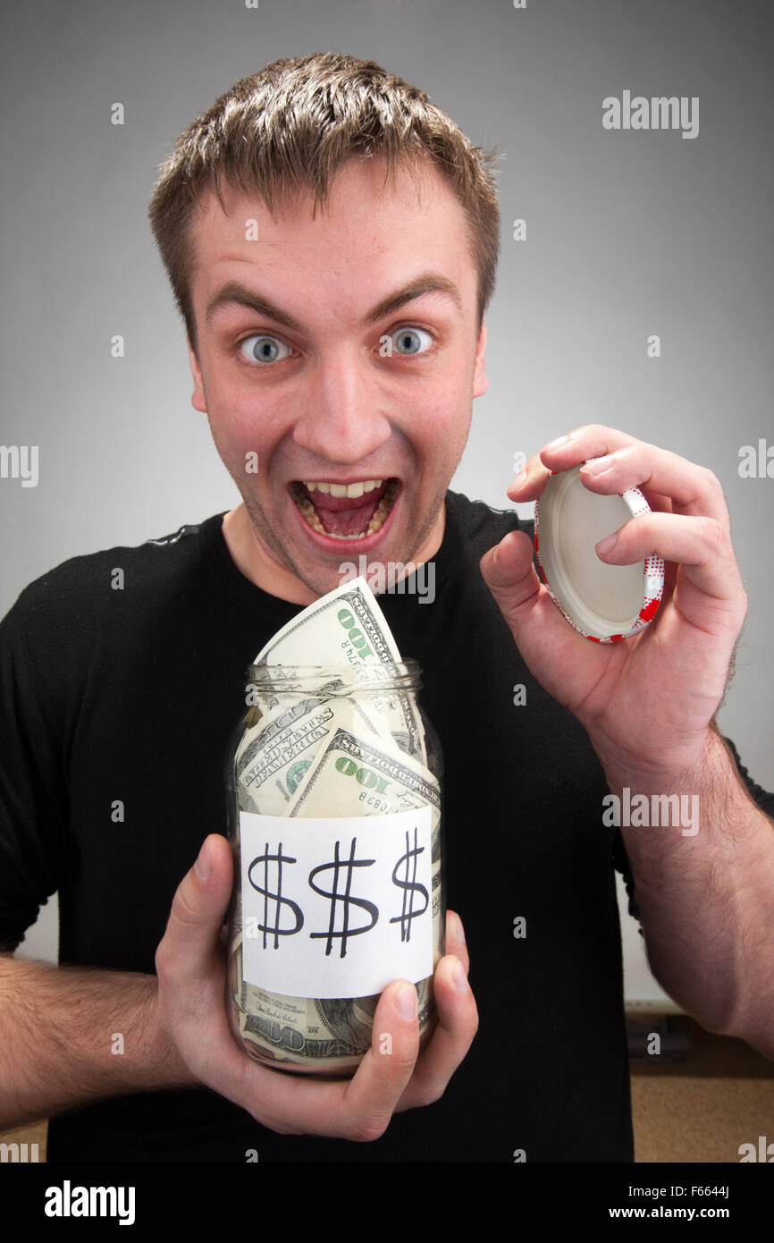 Portrait of happy man with canned money Stock Photo - Alamy