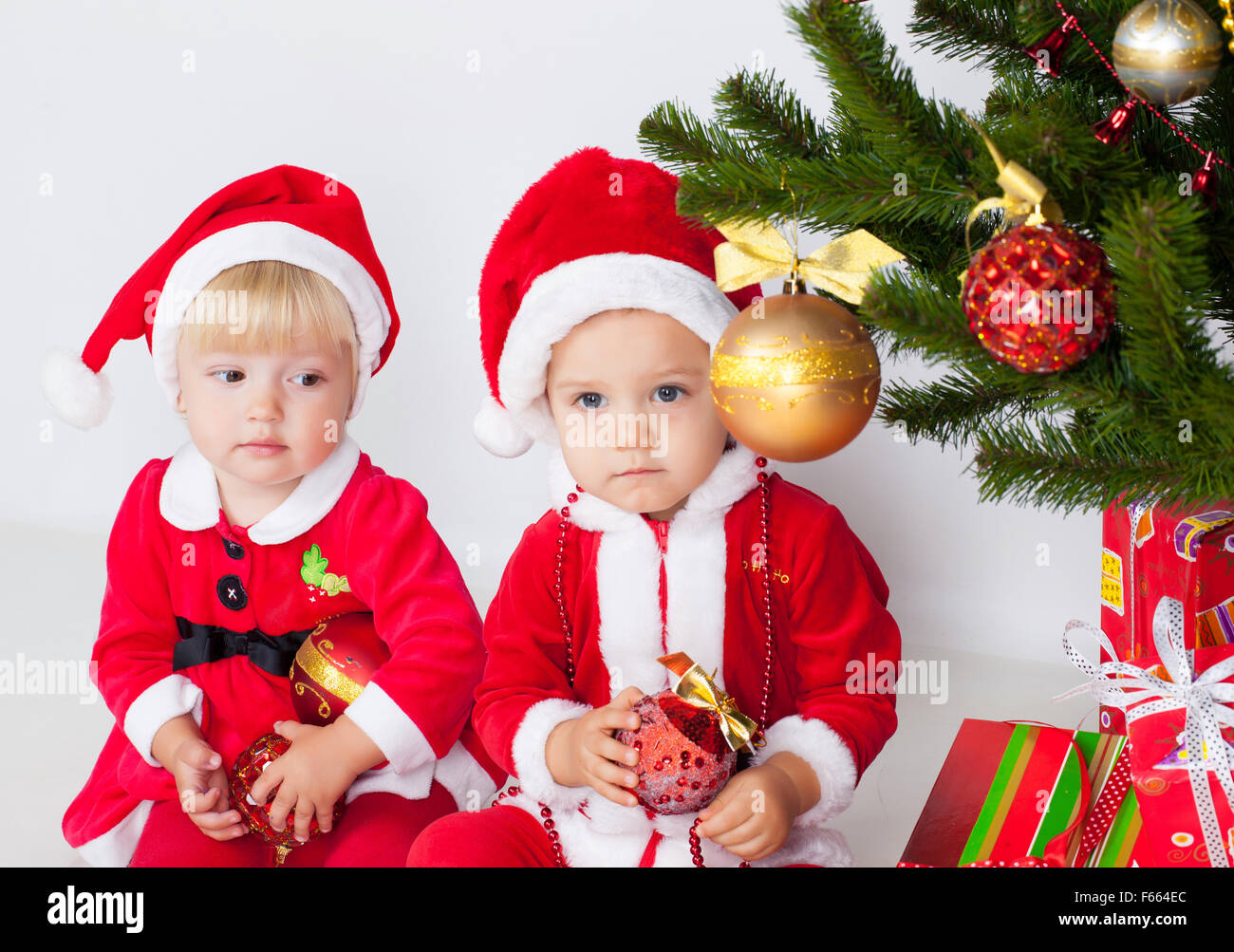 Two children under christmas pine Stock Photo - Alamy