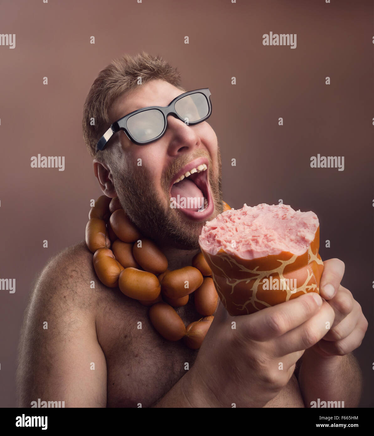 Hungry man with sausages round his neck eats a big wurst Stock Photo ...