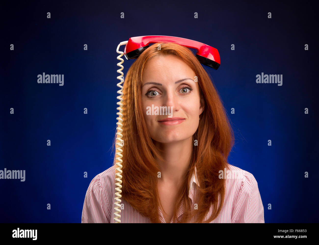 Redhead woman with red telephone on her head Stock Photo - Alamy