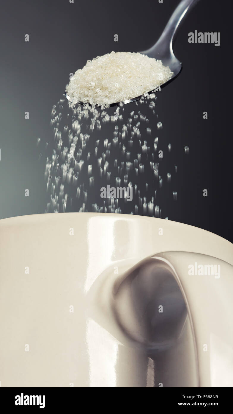 Sugar being poured into a cup Stock Photo - Alamy