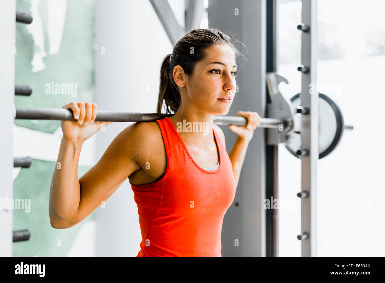 Focused young beautiful woman lifting weights in a gym Stock Photo - Alamy