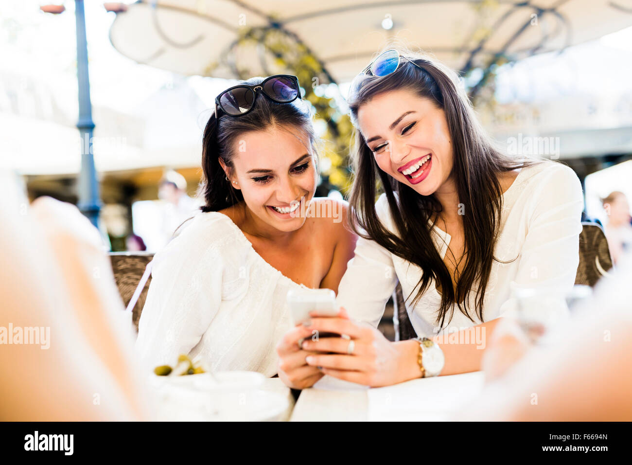 Two young girls talking and smiling during lunch break Stock Photo - Alamy