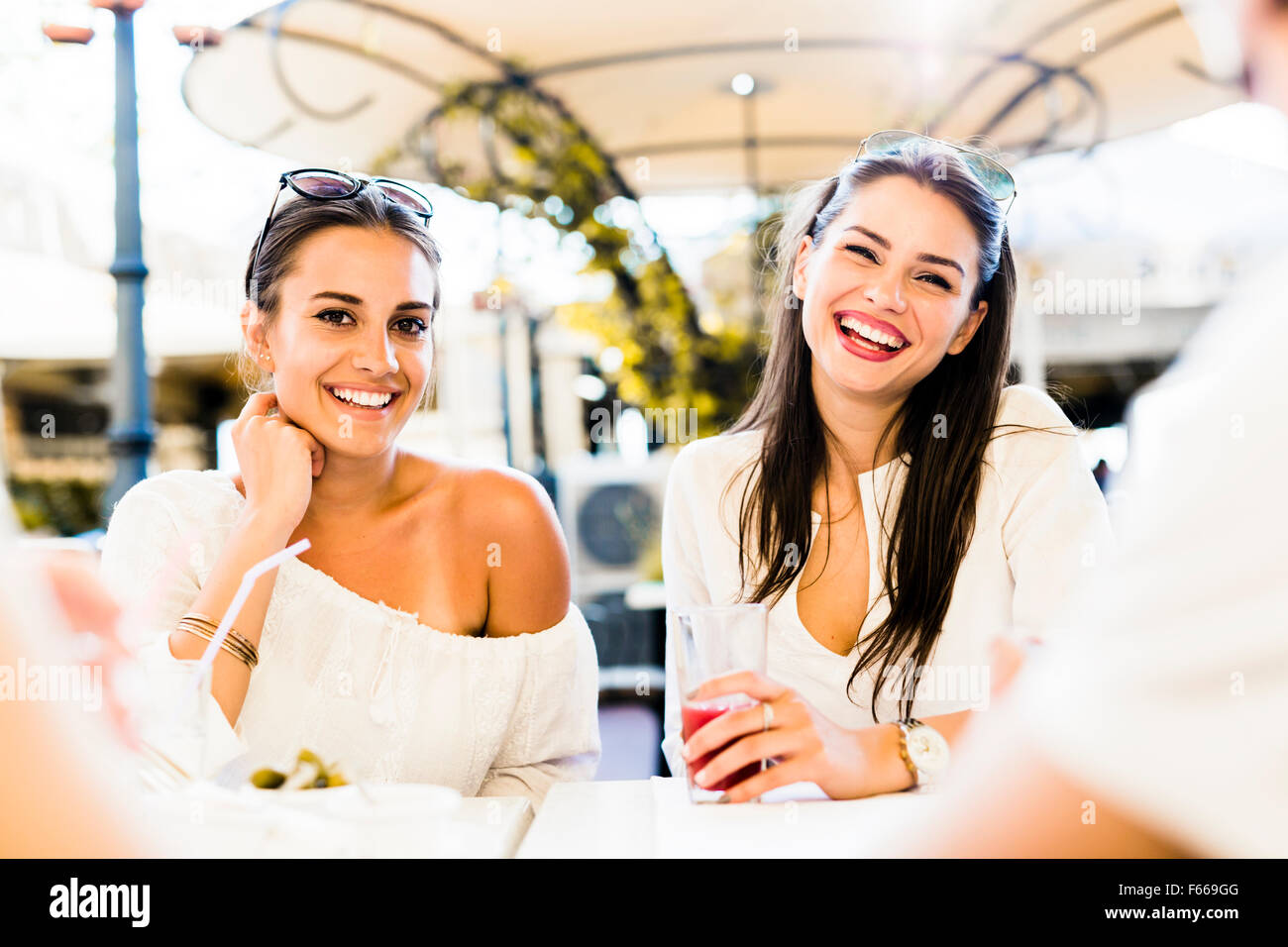 Two young girls talking and smiling during lunch break Stock Photo - Alamy