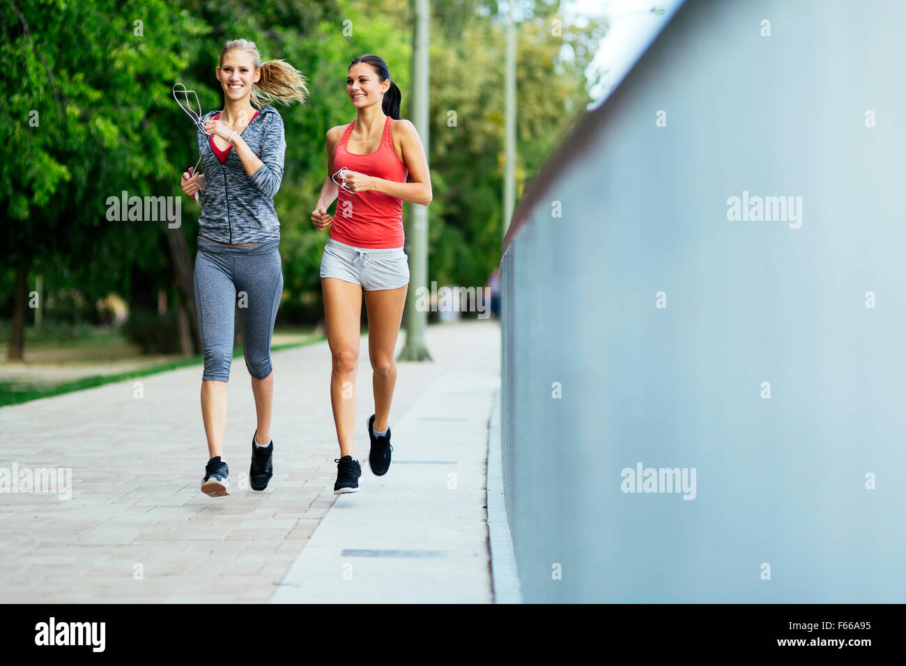 Two women exercising by jogging in city Stock Photo - Alamy
