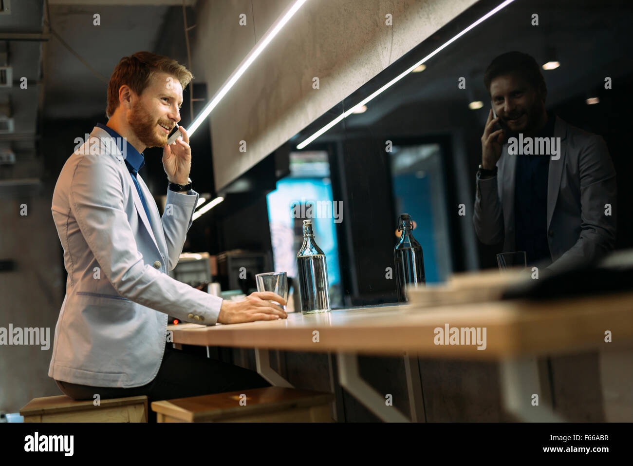 Busy businessman talking on phone while sitting in a pub Stock Photo ...