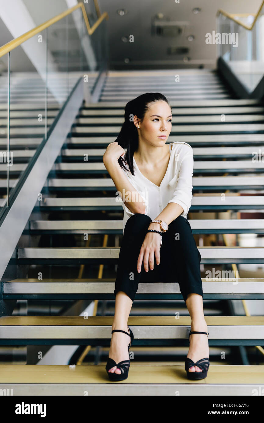 Businesswoman sitting on stairs and thinking. Fashion style photo Stock ...