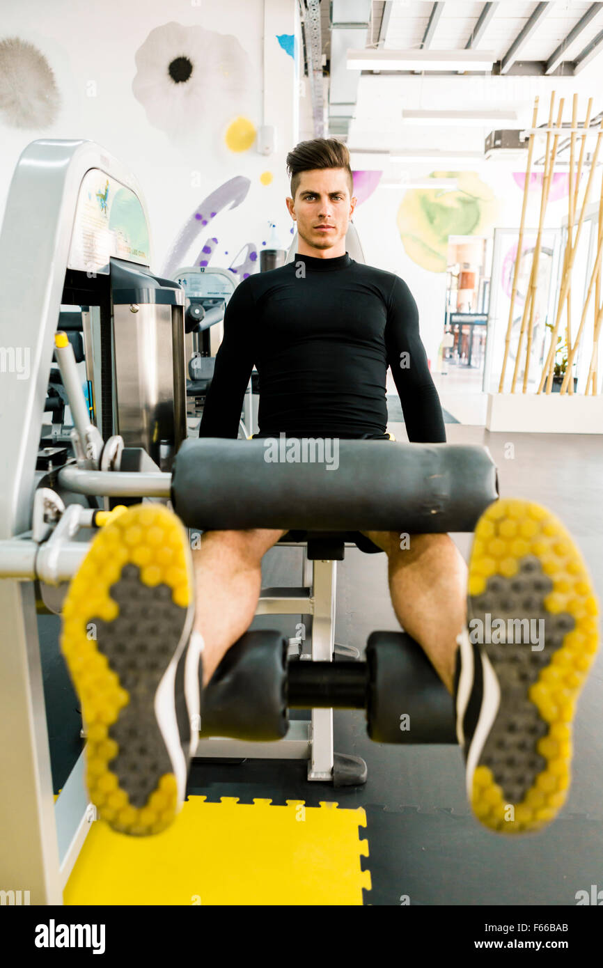 Young handsome man working out in a gym and living a healthy lifestyle ...