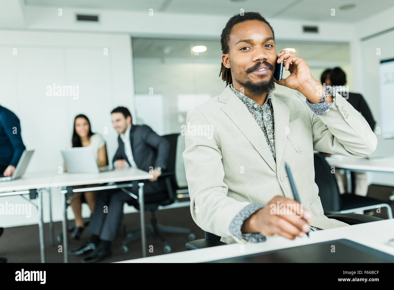 Black handsome graphics designer with dreadlocks using digitizer in a ...