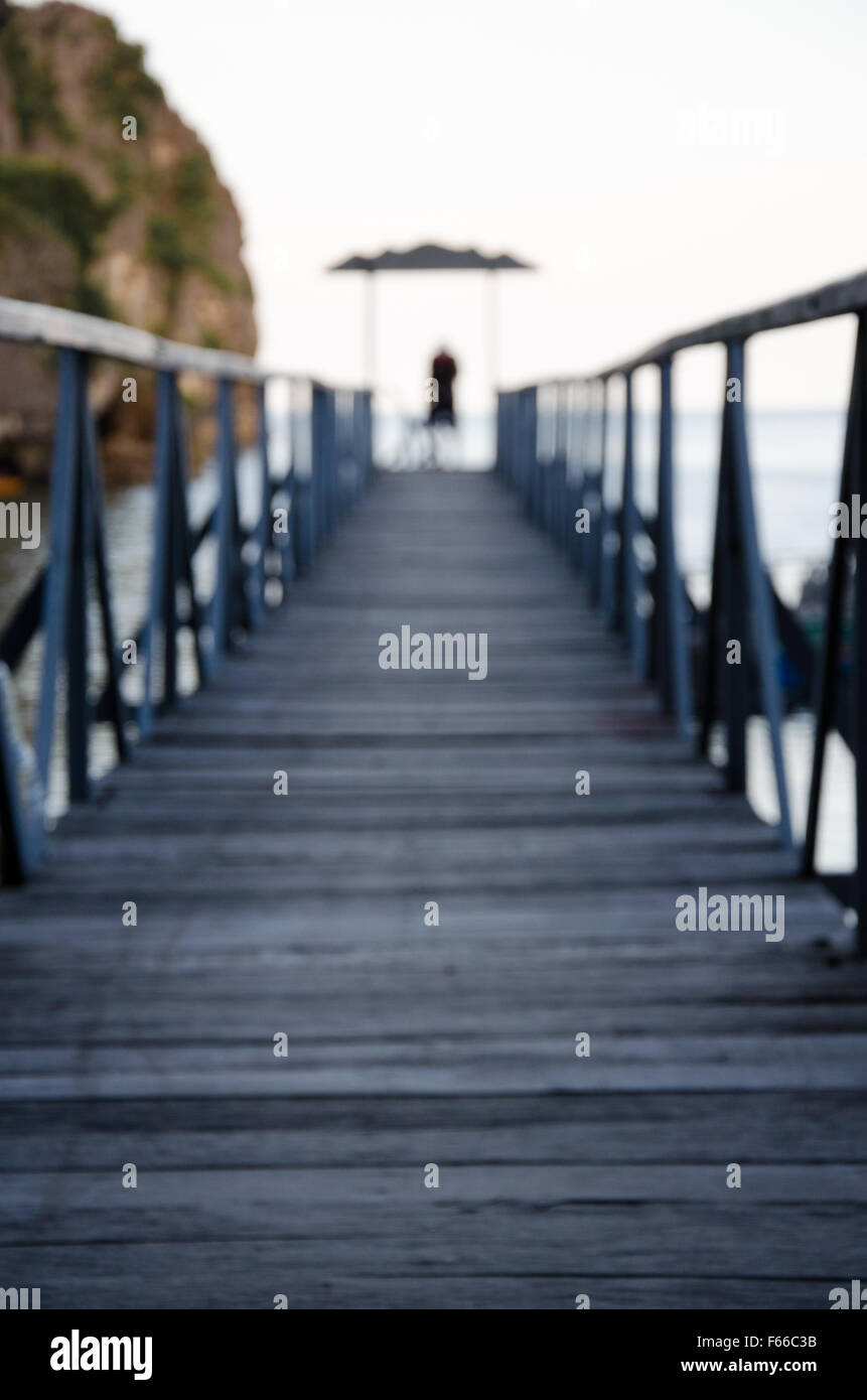 Man looking out to see from end of long pier Stock Photo - Alamy