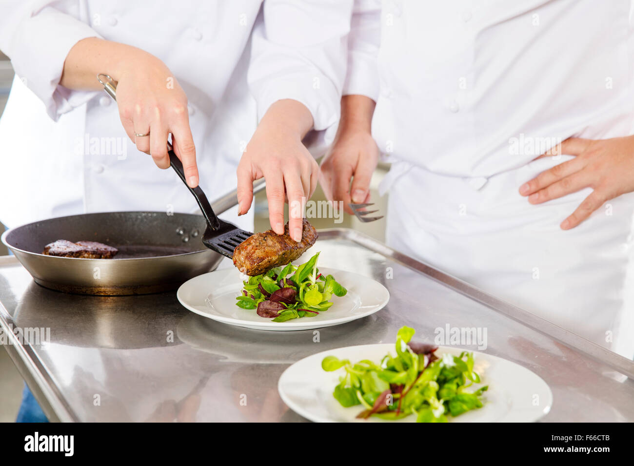 Professional chefs prepares steak dishes at restaurant Stock Photo - Alamy