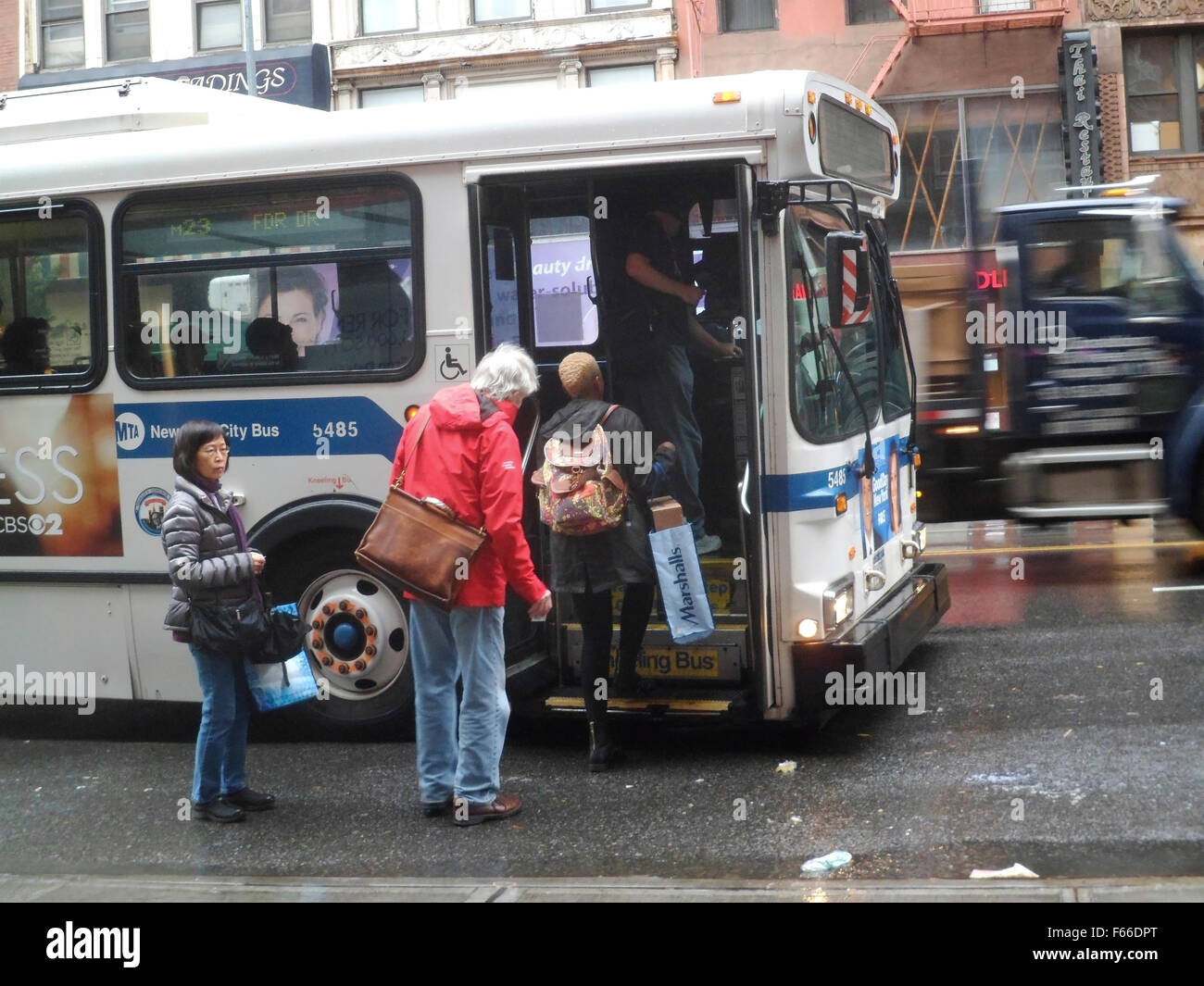 Commuters board an M23 bus in the Chelsea neighborhood of New York on ...