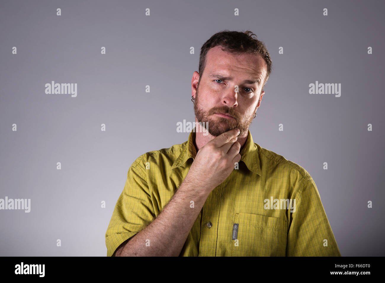 Perplexed man stroking beard Stock Photo - Alamy