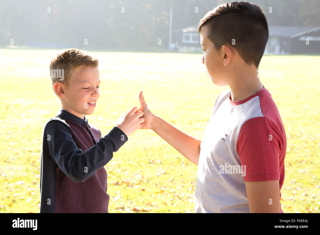 Two boys playing a hand game outside Stock Photo - Alamy