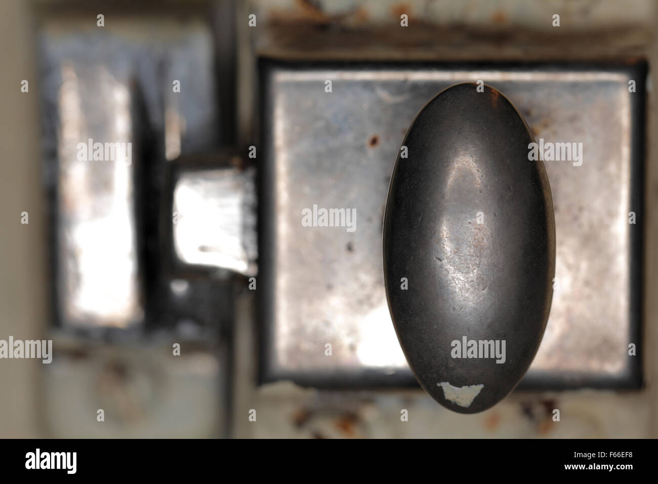 An antique turn-latch made of steel showing scratches and wear marks ...