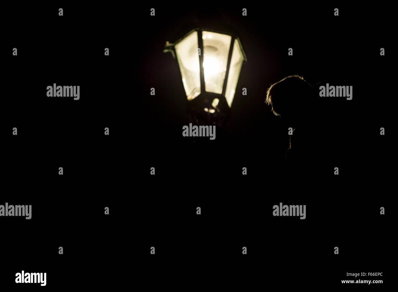 A man under a gaslight at night Stock Photo - Alamy