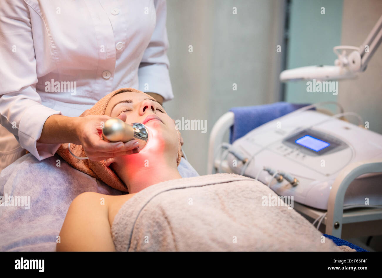 Young woman receiving facial treatment with electroporation beauty ...