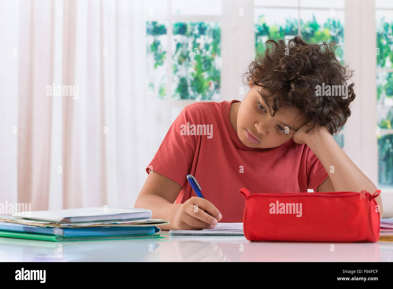 Sad schoolboy doing homework Stock Photo - Alamy