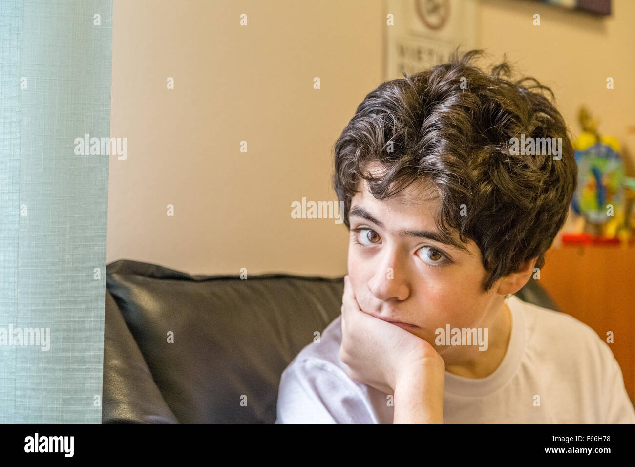 Caucasian teenage boy waits in the waiting room in the medical office ...