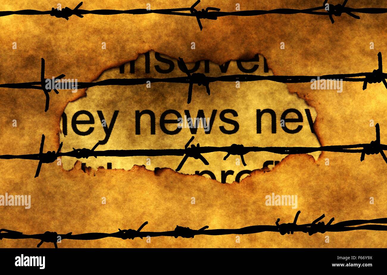 News paper hole againsr barbwire Stock Photo - Alamy
