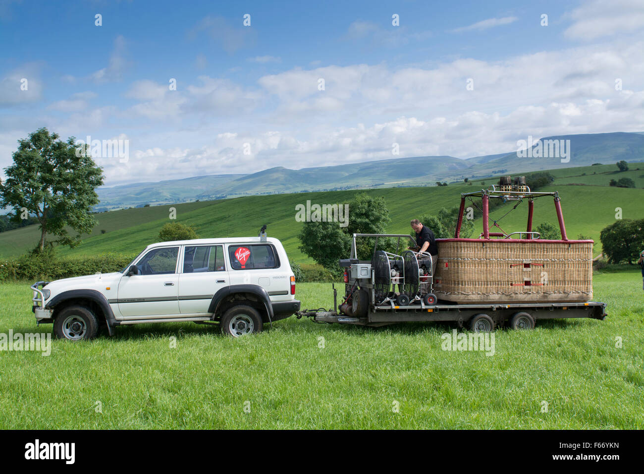 4x4 vehicle and trailer picking up a hot air balloon from field after a ...