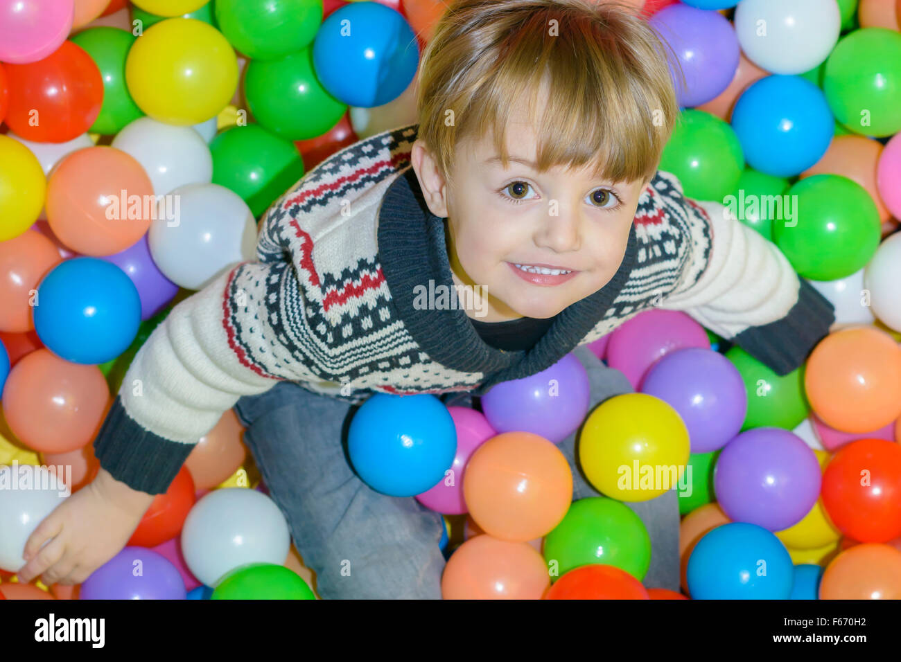 Happy Kid Playing with balls at kindergarten Stock Photo - Alamy
