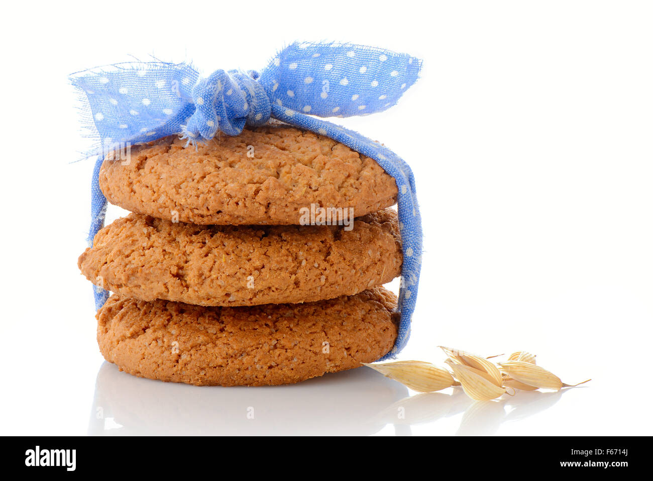 Stack of three homemade oatmeal cookies tied with blue ribbon in small ...