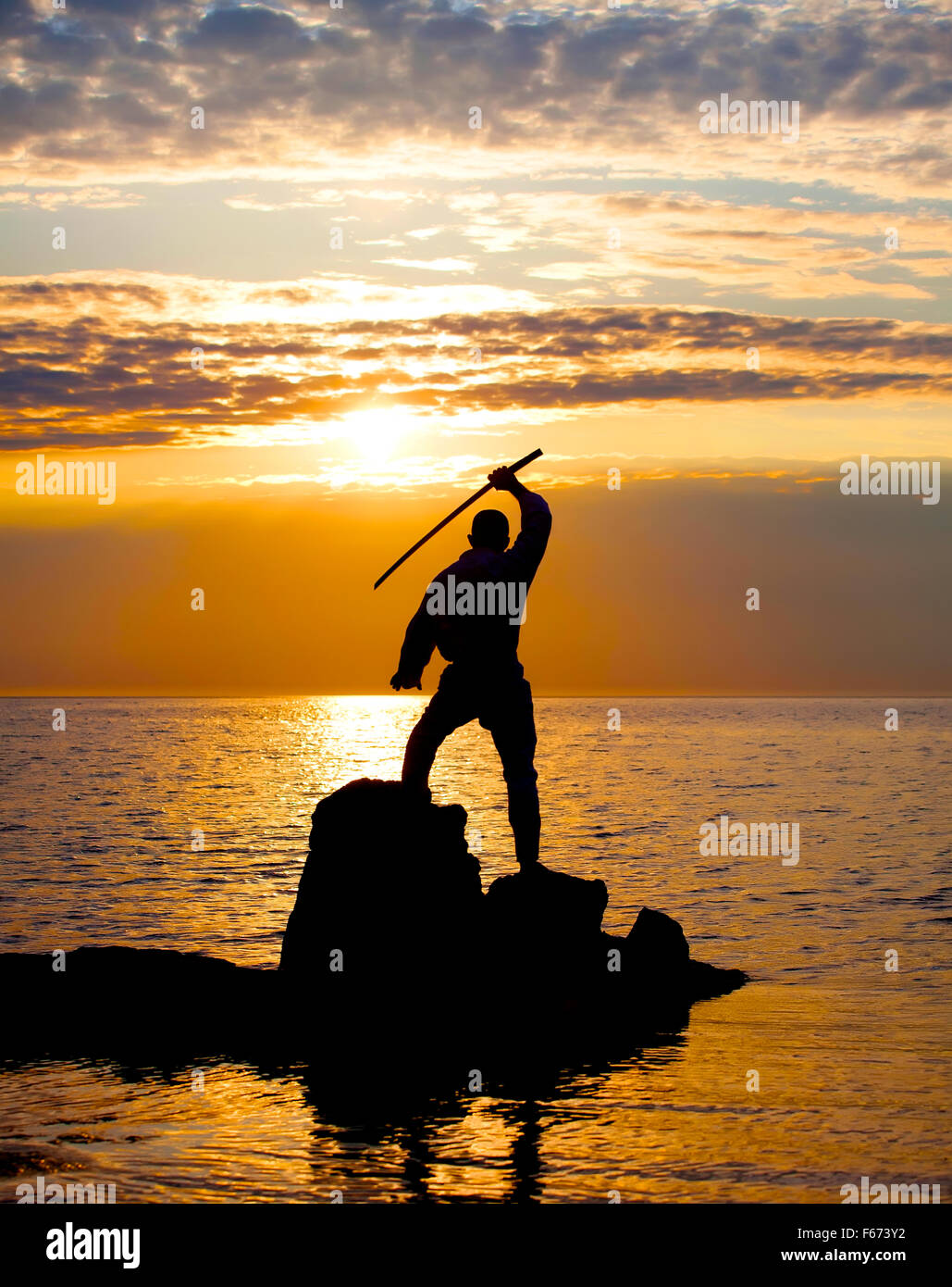 Man with sword on sunset Stock Photo - Alamy