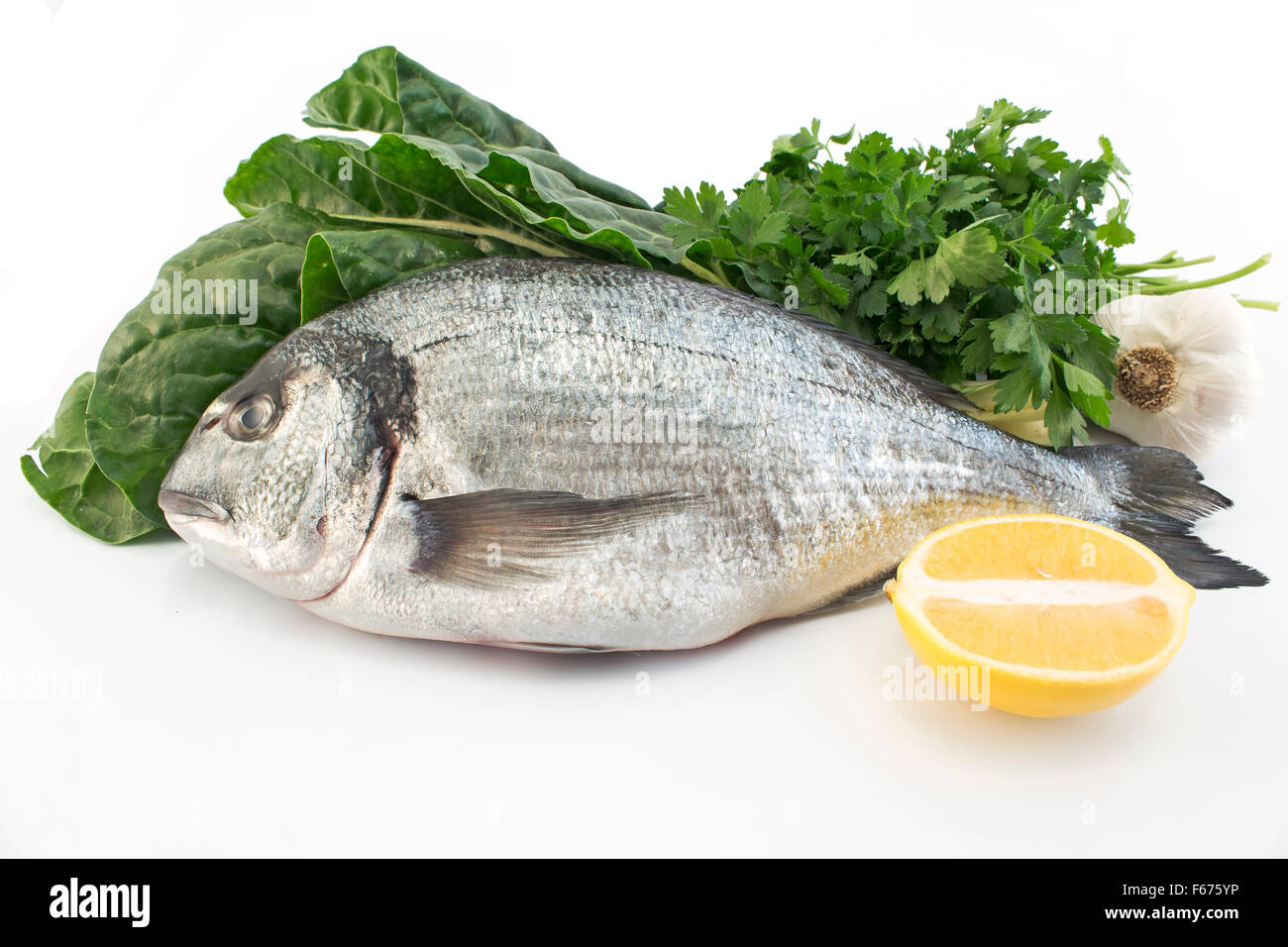 Fish dorade with swiss chard, parsley, garlic and lemon Stock Photo - Alamy