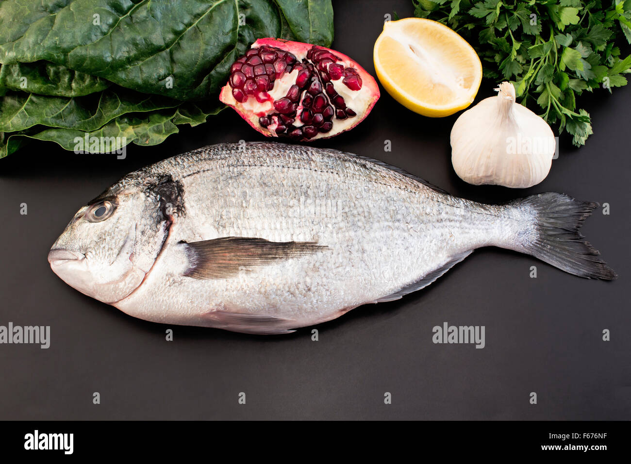 Fish dorade on a black background Stock Photo - Alamy