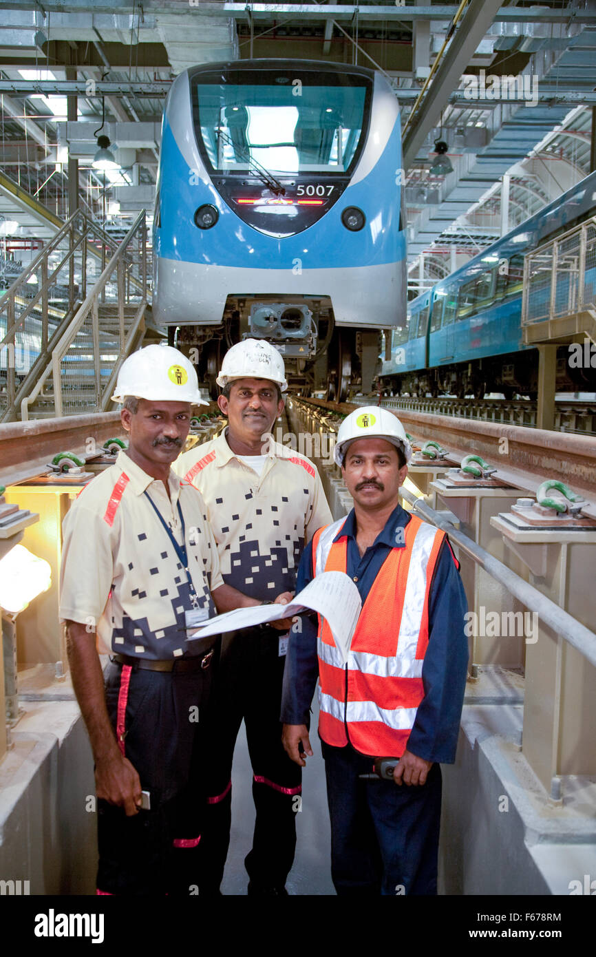 Engineers working under tube train in Dubai Metro Stock Photo - Alamy
