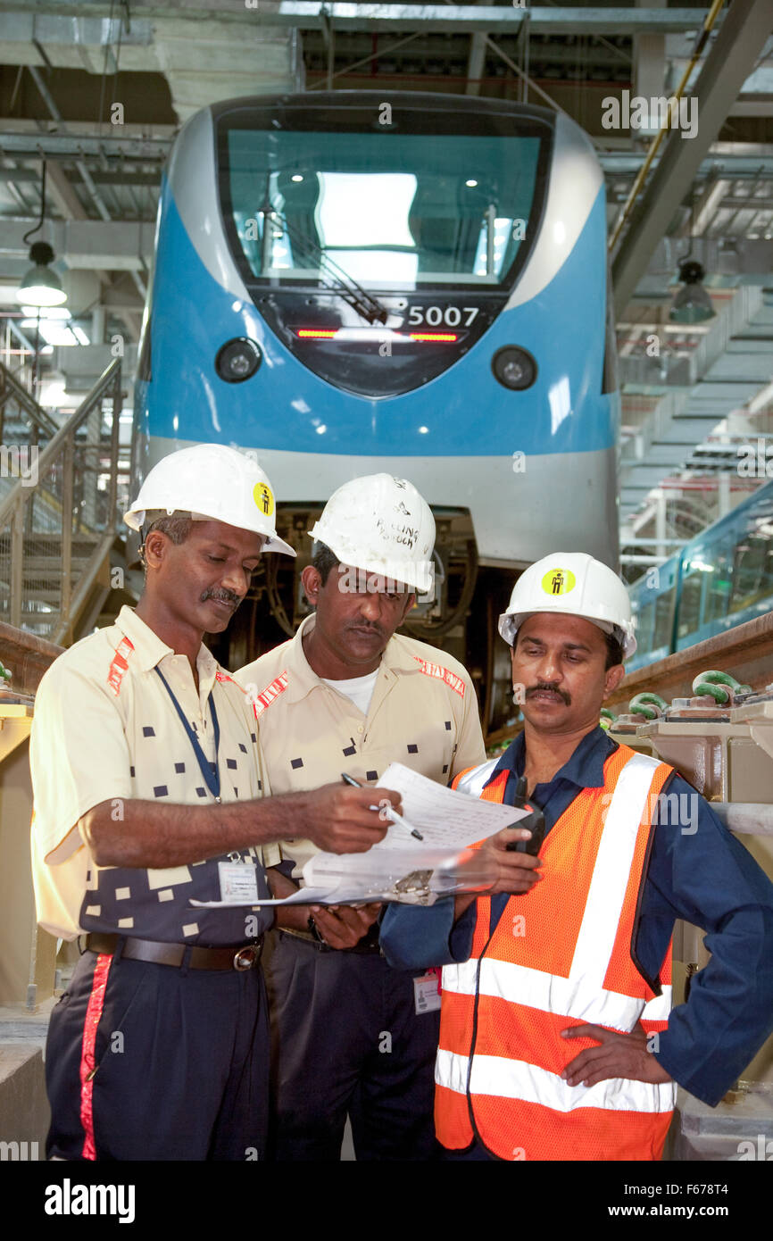 Engineers working under tube train in Dubai Metro Stock Photo - Alamy