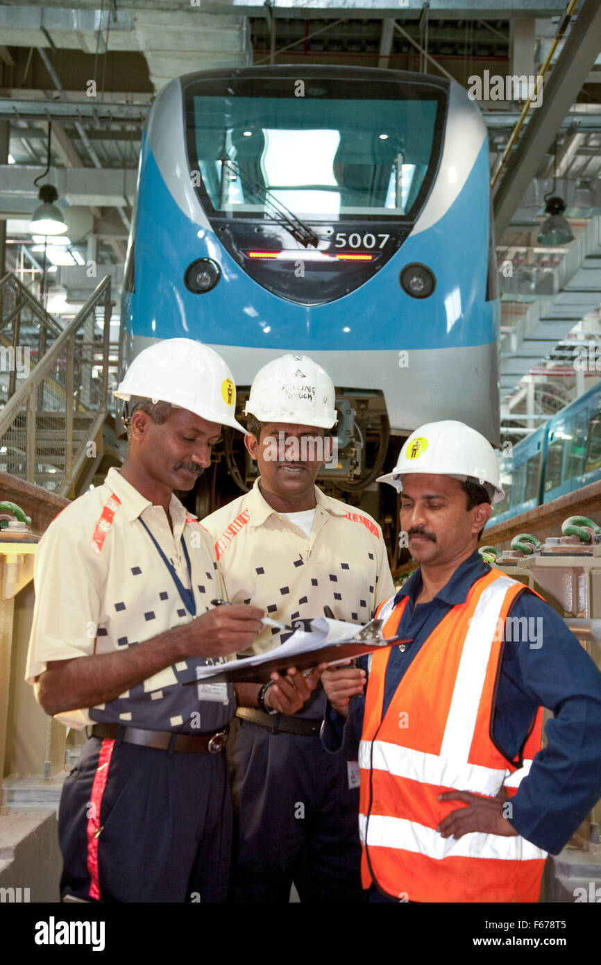 Engineers working under tube train in Dubai Metro Stock Photo - Alamy