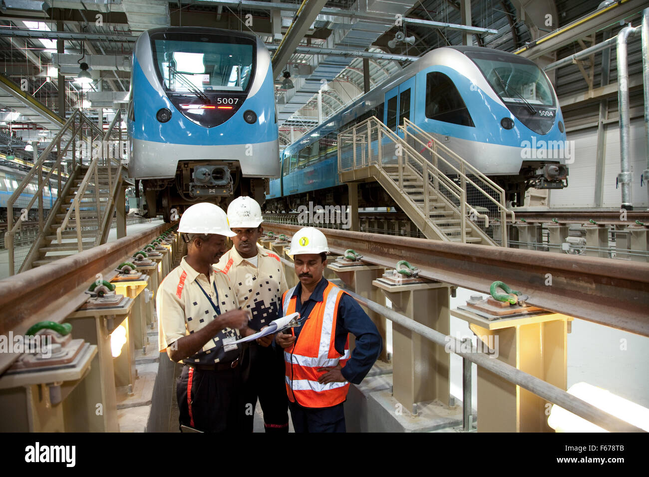 Engineers working under tube train in Dubai Metro Stock Photo - Alamy