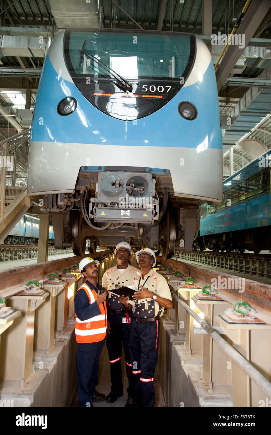 Engineers working under tube train in Dubai Metro Stock Photo - Alamy