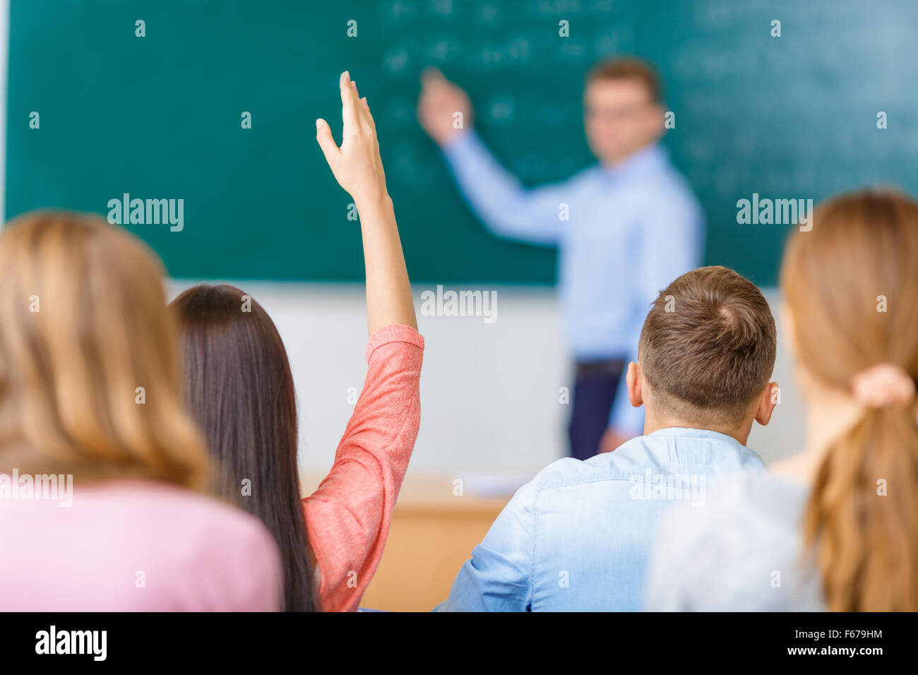 One of students raises arm to answer the question Stock Photo - Alamy