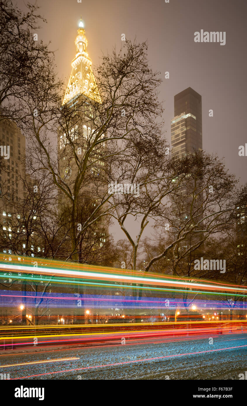 Skyscrapers during snowstorm on Madison Square Park. Car tail lights ...