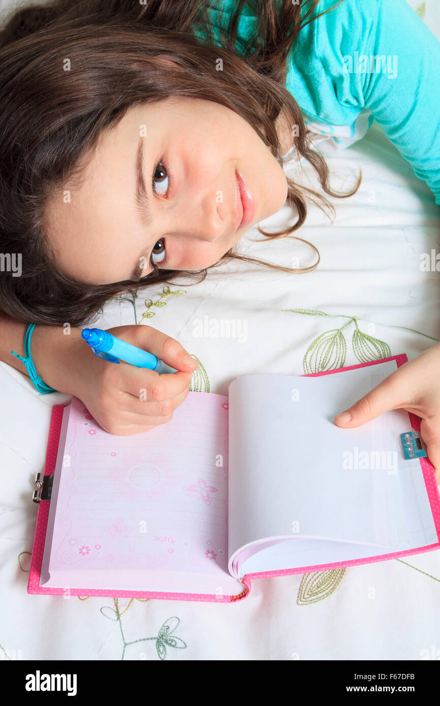 Girl writing diary in bed Stock Photo - Alamy