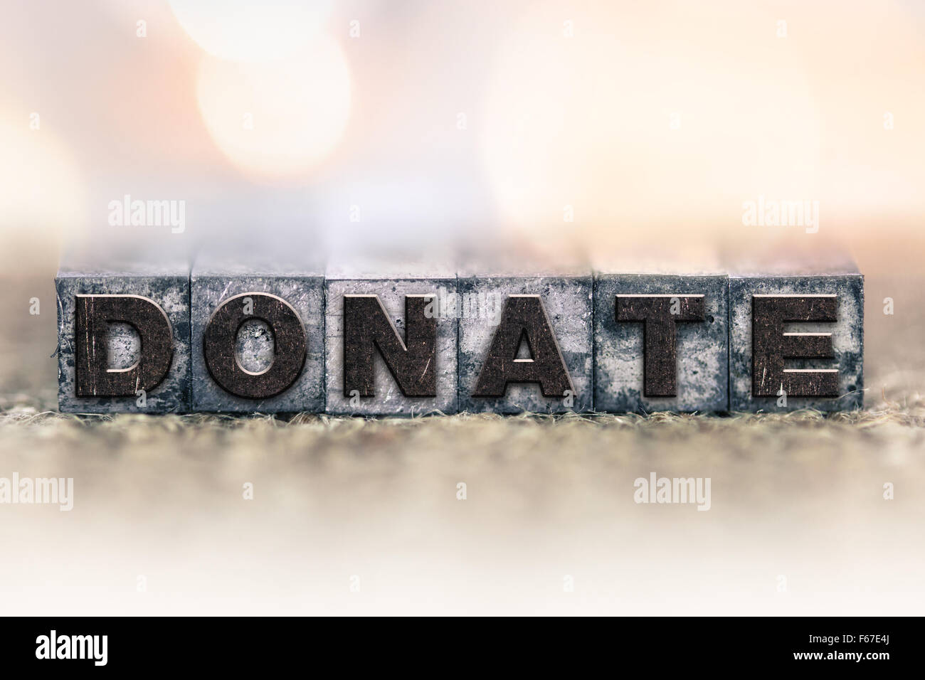 The word "DONATE" written in vintage ink stained letterpress type Stock ...