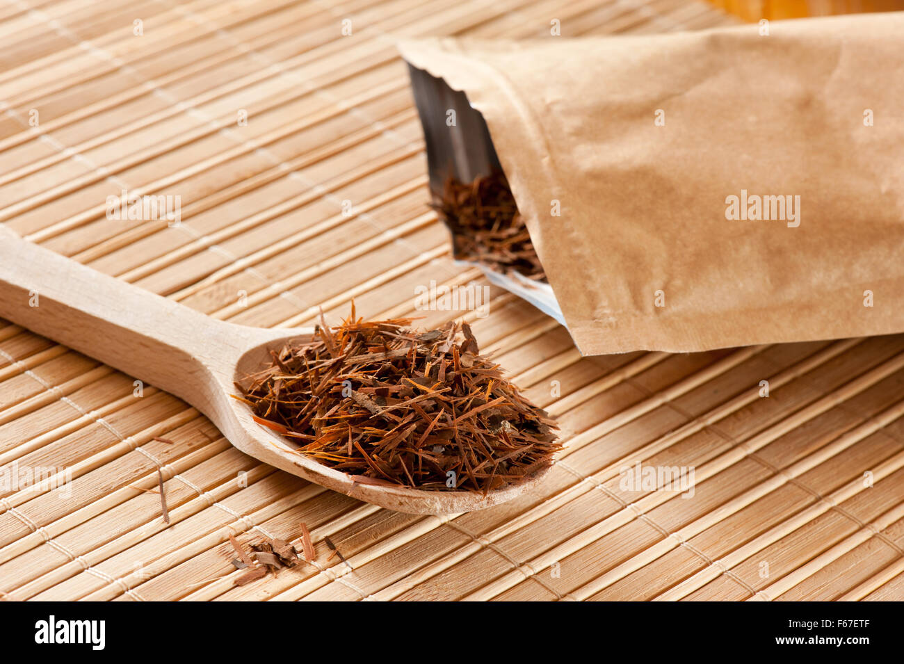 Lapacho herbal tea portion lying on the wooden spoon on mat, pile of ...