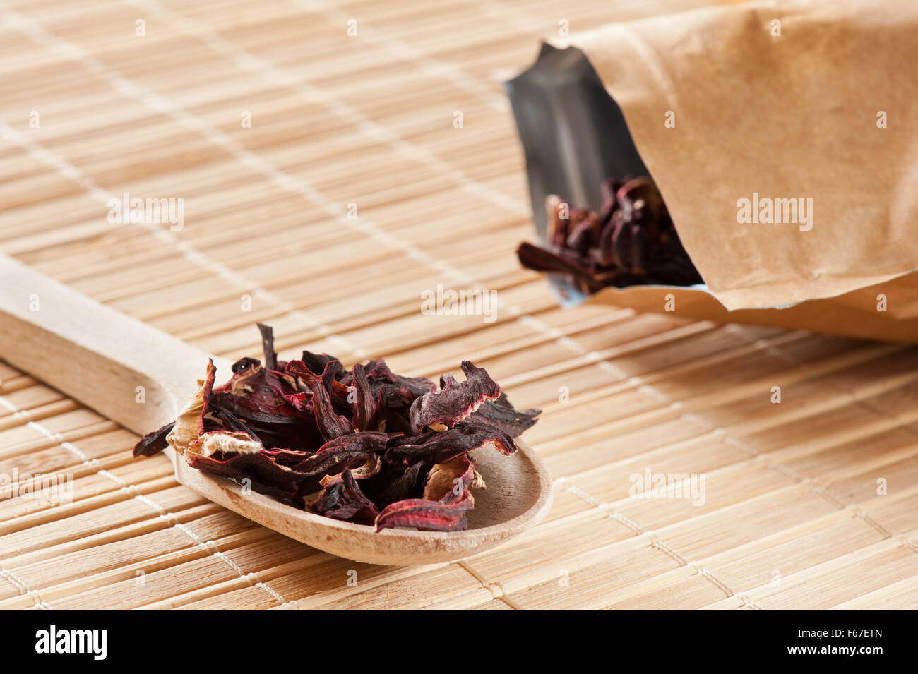 Dried Roselle Hibiscus sabdariffa petals tea portion lying on wooden ...