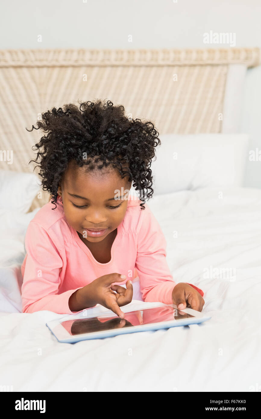 Young girl using tablet on bed Stock Photo - Alamy